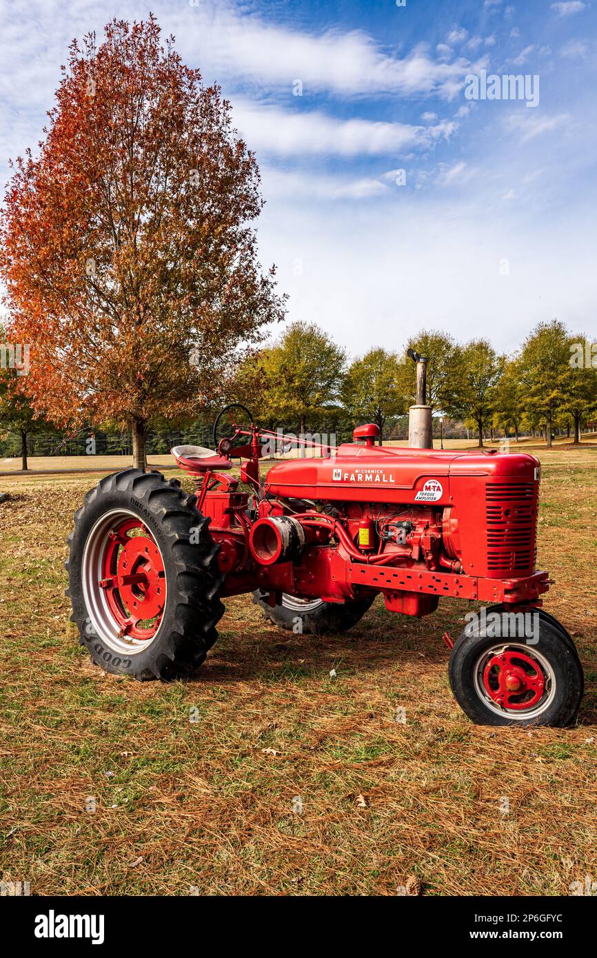 A red "Mccormick Farmall" tractor parked in a grassy field, vertical ...