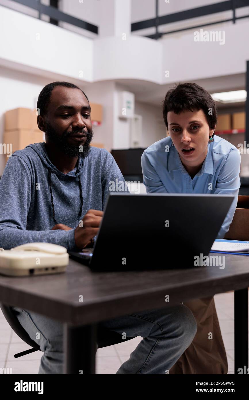 Manager and supervisor looking at transportation logistics on laptop ...