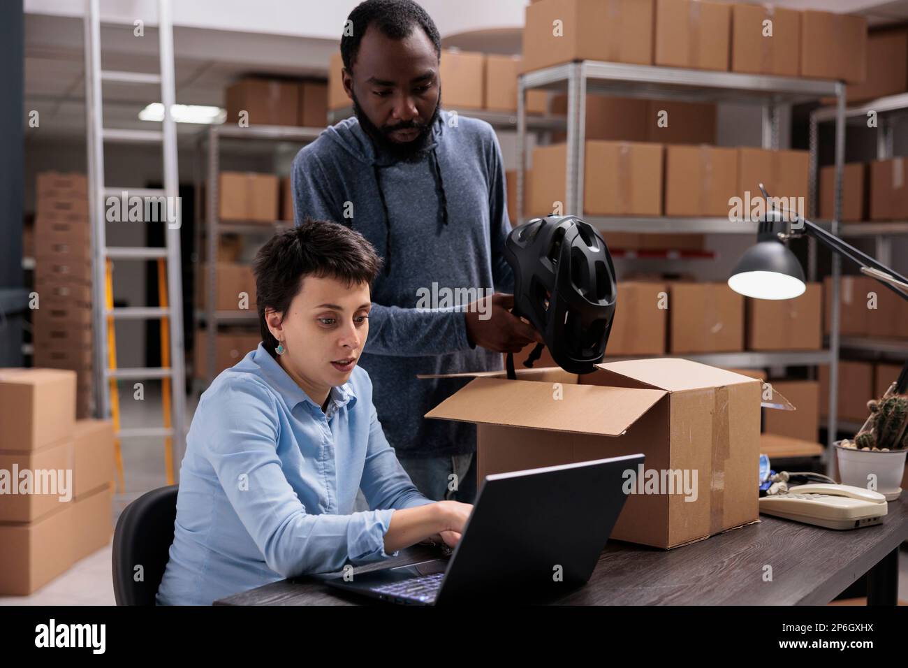Storehouse employee putting customer helmet order in carton box ...