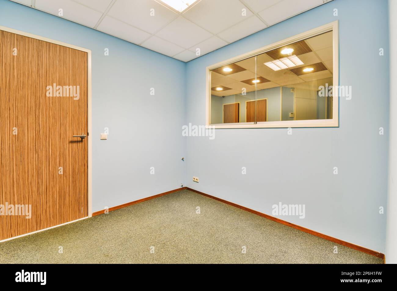 an empty room with a door and mirror on the wall in front of it, as ...