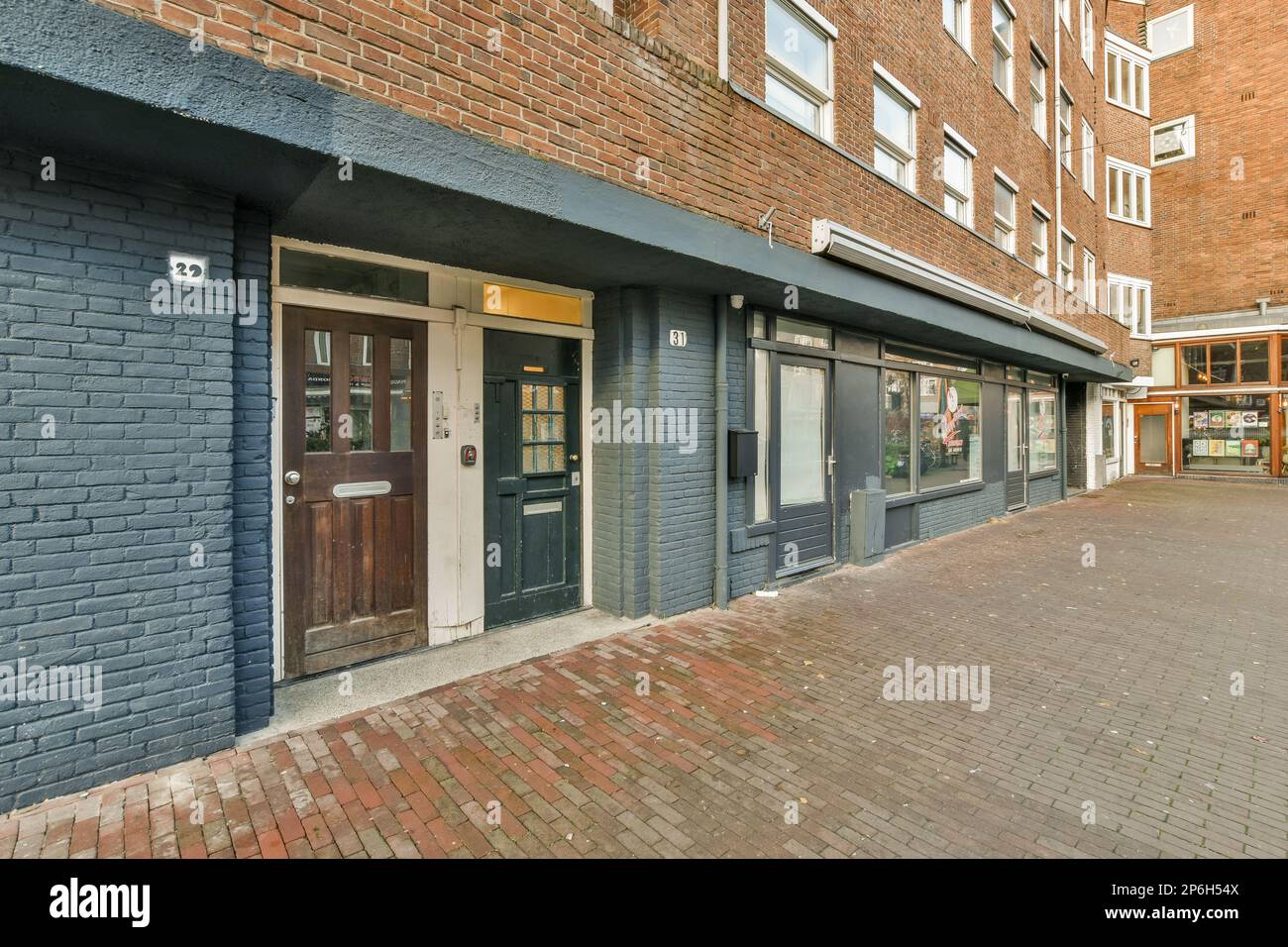 a bricked building with an open door on the front and two windows in ...