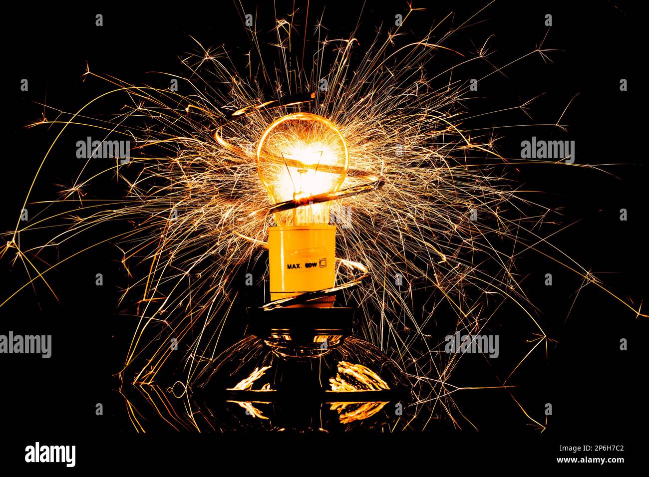 Isolated lighted up incandescent lamp with fire sparks and filament in ...