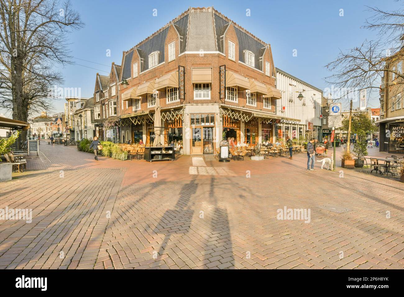 a town square with people walking and sitting on benches in the middle ...