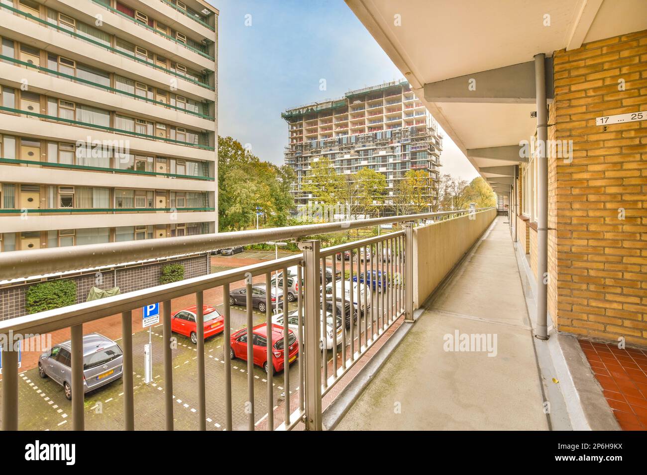 a balcony with cars parked on the sidewalk and apartment buildings in ...