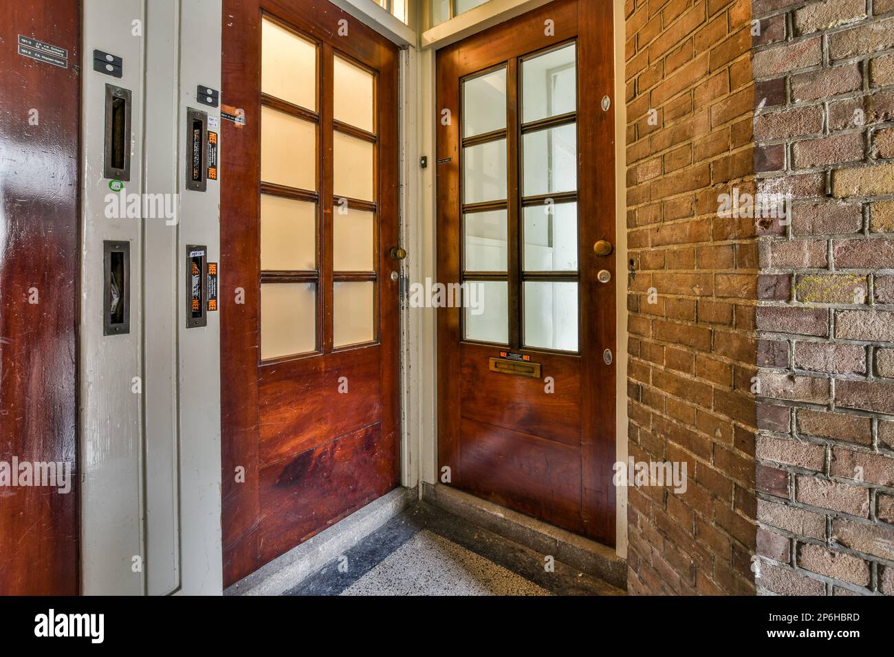 a brick building with a wooden front door and glass paneled entryway to ...