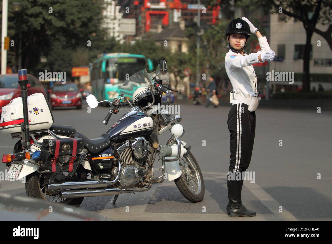 A traffic policewoman directs vehicles on a road in southwest China's ...
