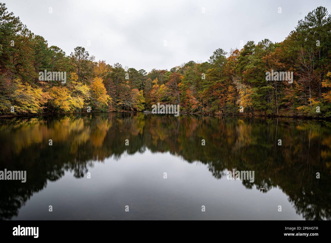 A lush fall forest mirrored in crystal clear Sibley Pond waters ...