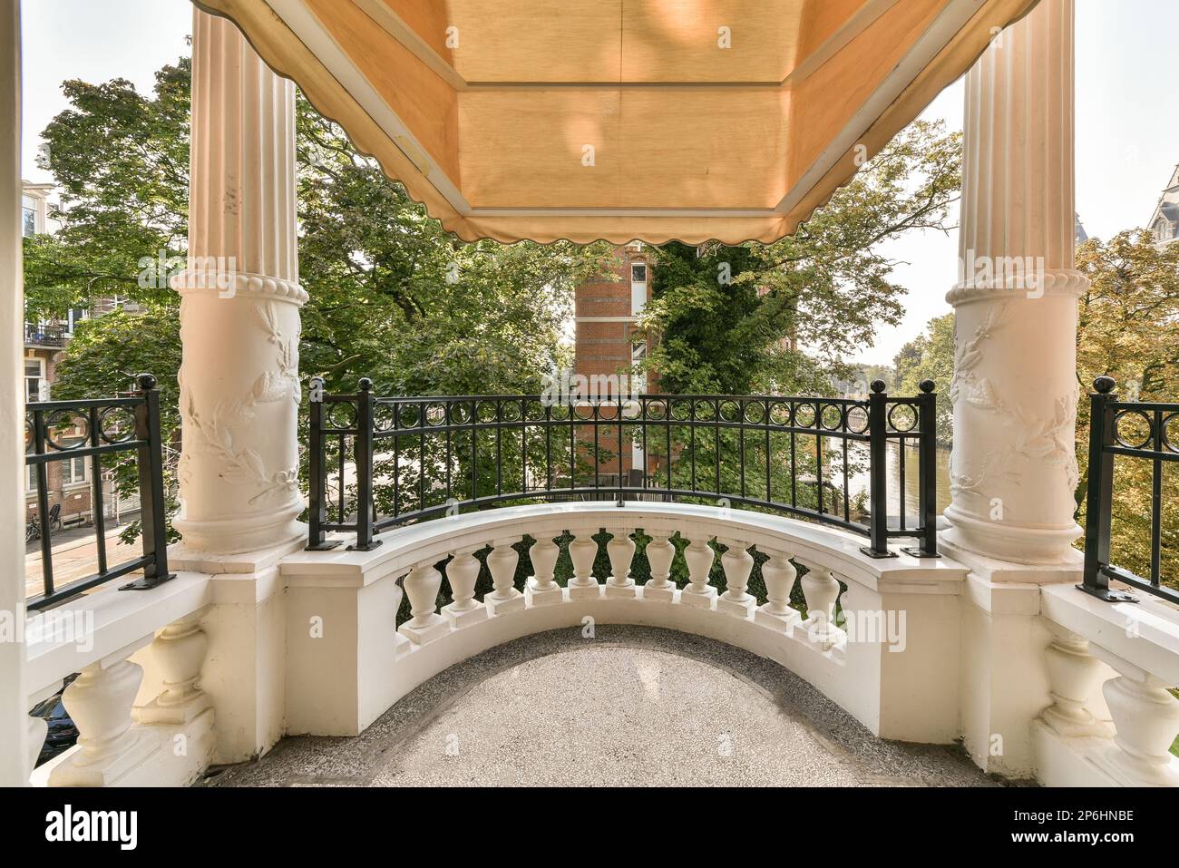 a balcony with railings and trees in the background, taken from inside ...