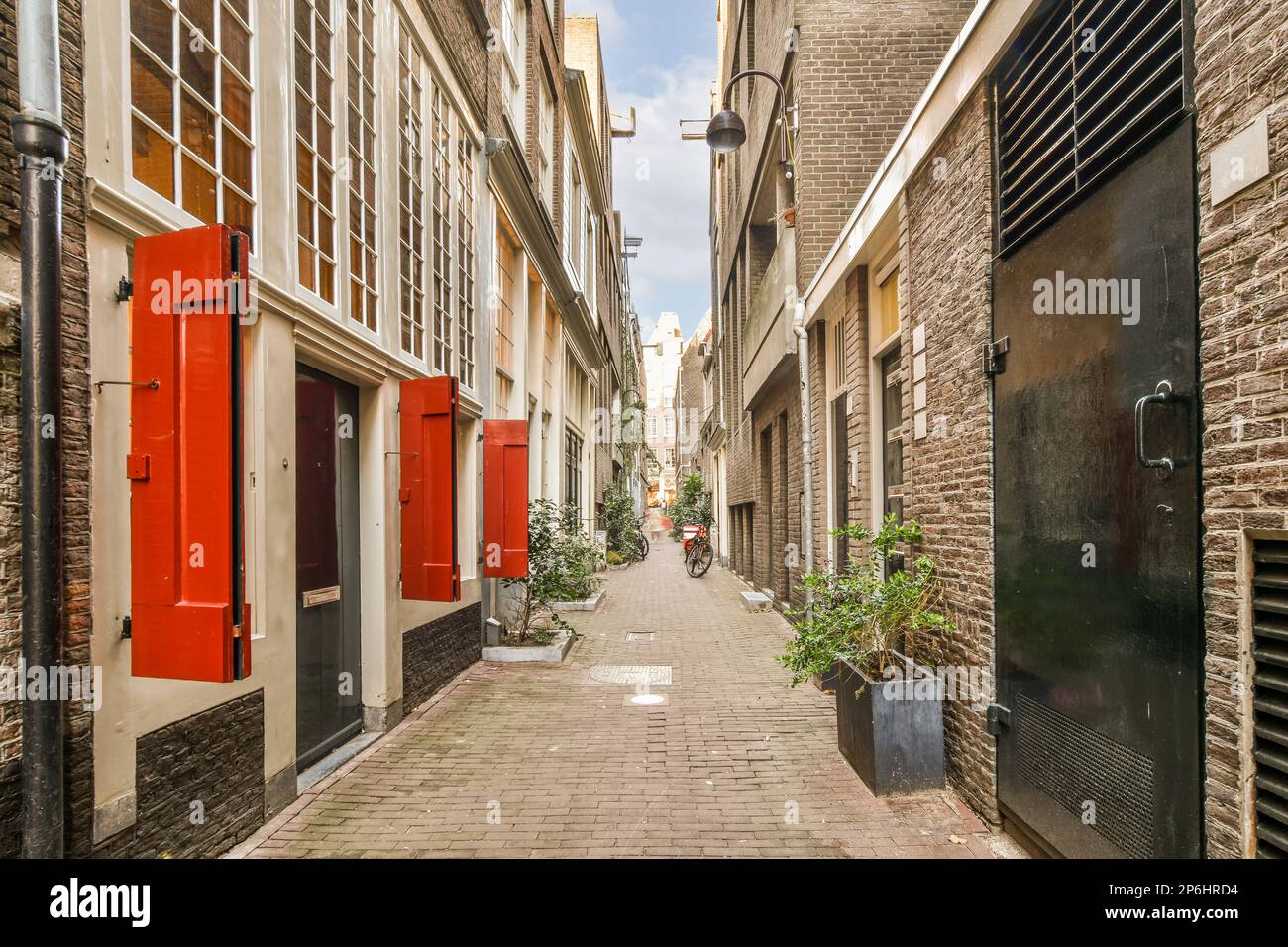 an alley with red doors and bricked buildings on both sides, in the ...