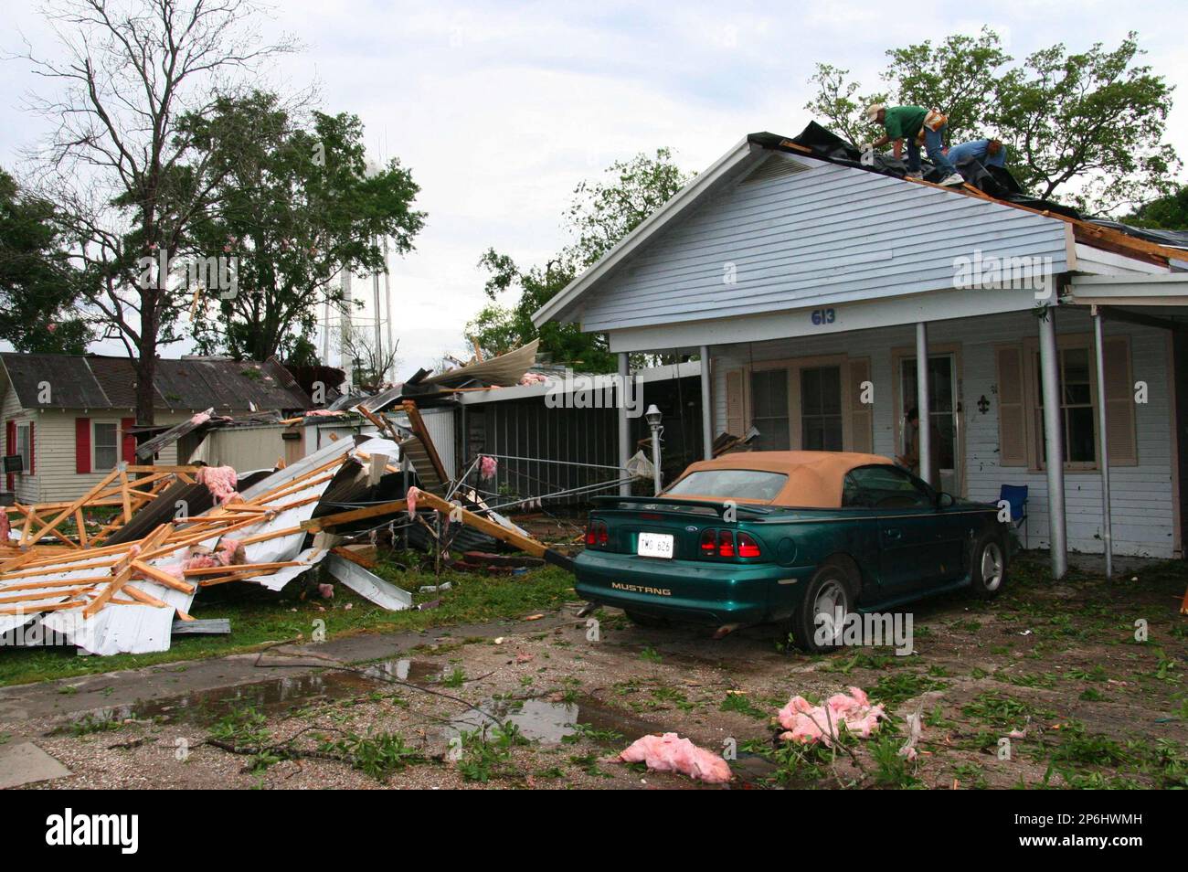 Crews work to temporarily repair Angela Wainright's roof after an EF-1 ...