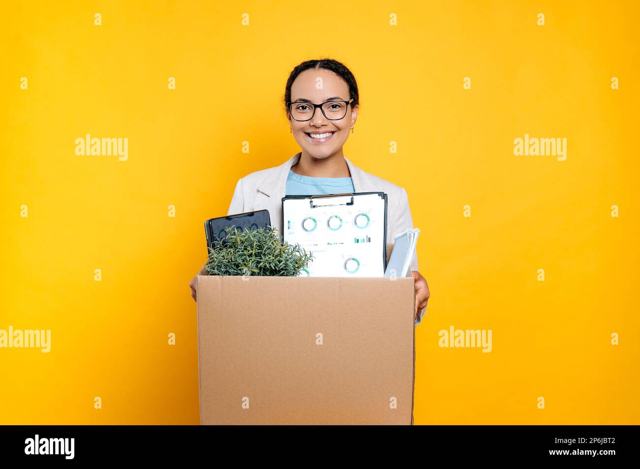Positive mixed race young woman with glasses got a new job, holding ... Positive mixed race young woman with glasses got a new job, holding ...