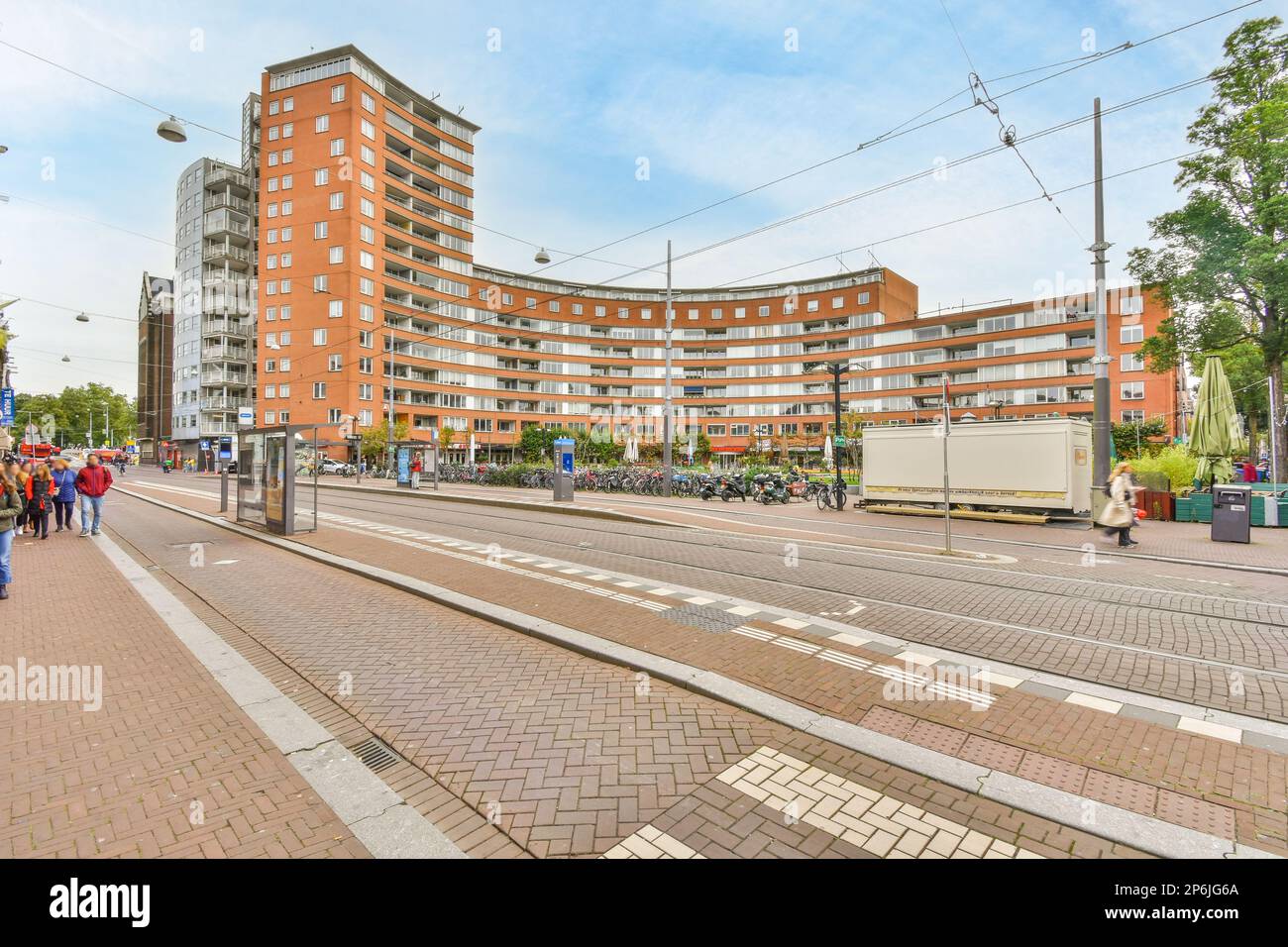 people walking down the street in front of an apartment building on a ...