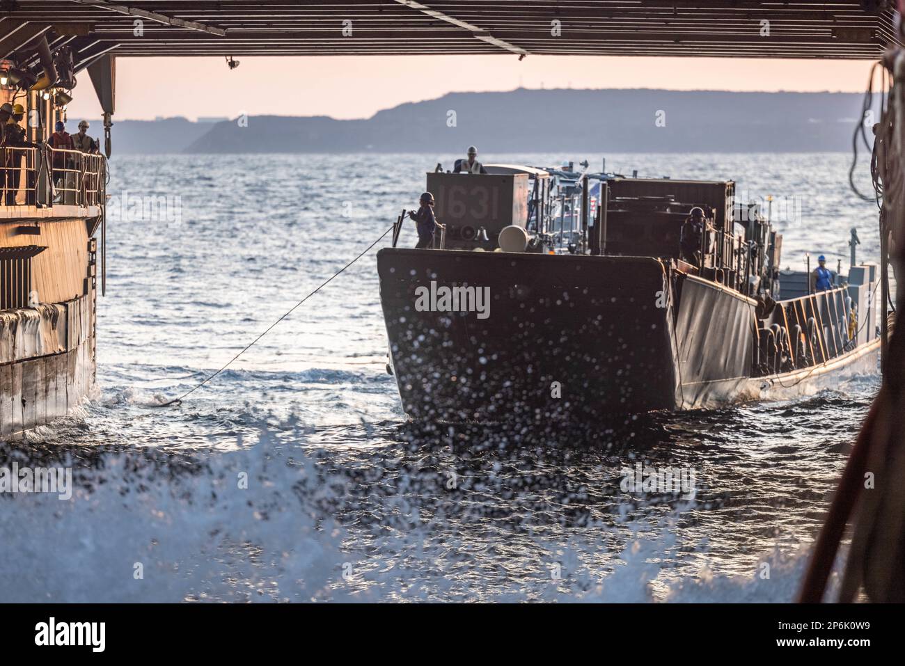 A landing craft, utility enters the well deck of the amphibious dock ...