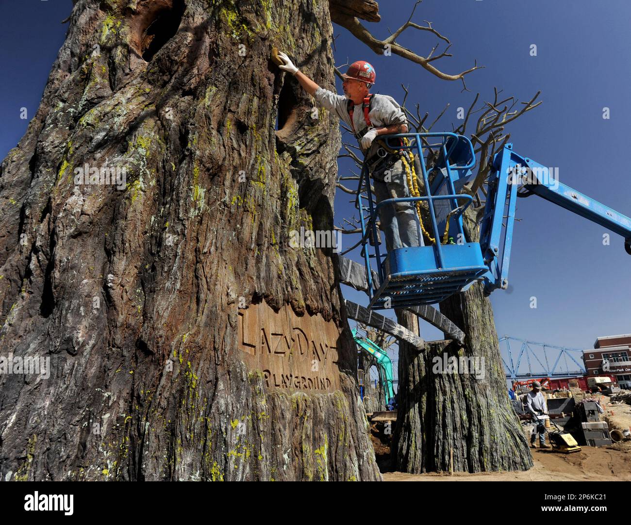 Artist and painter Mike Perry with Cost of Wisconsin Inc. applies paint ...