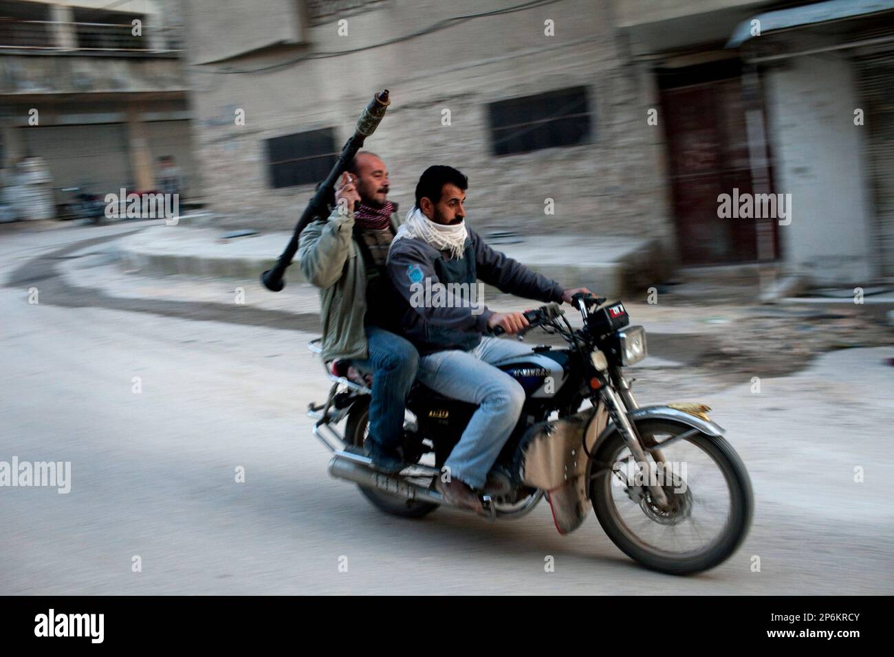 Supporters of the Free Syrian Army ride a motorcycle with a rocket ...