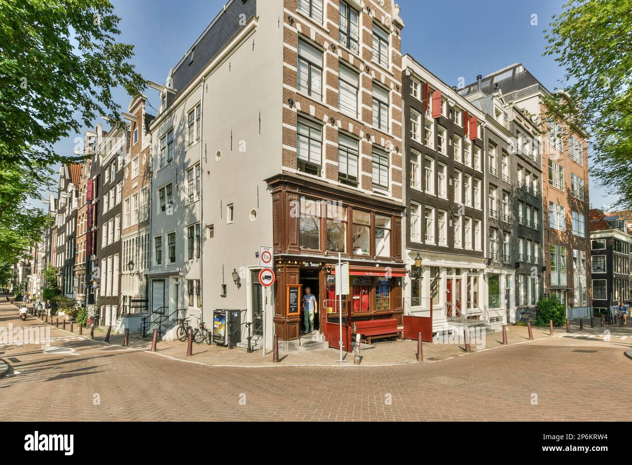 a street corner with buildings in the background and people walking on ...