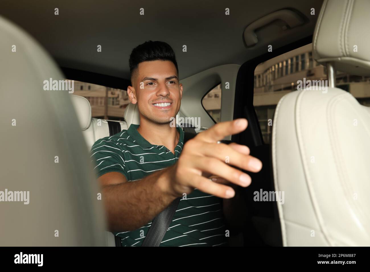 Man sitting on backseat of modern taxi Stock Photo - Alamy