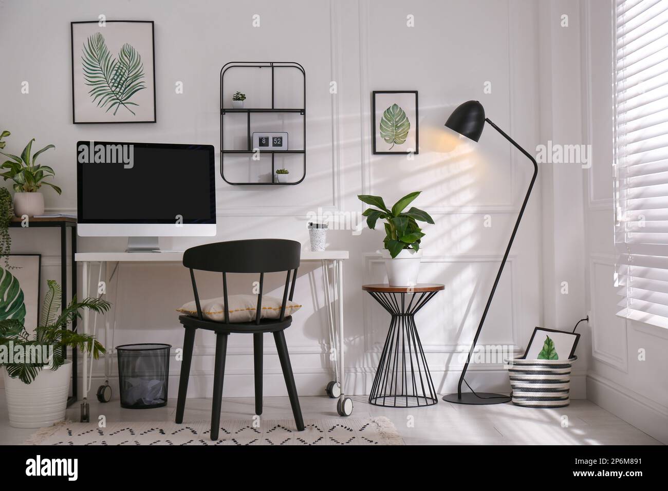 Comfortable workplace with modern computer and houseplants in room ...