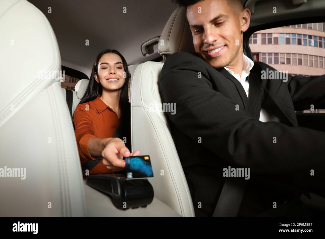 Young woman paying for service using credit card via payment terminal ...
