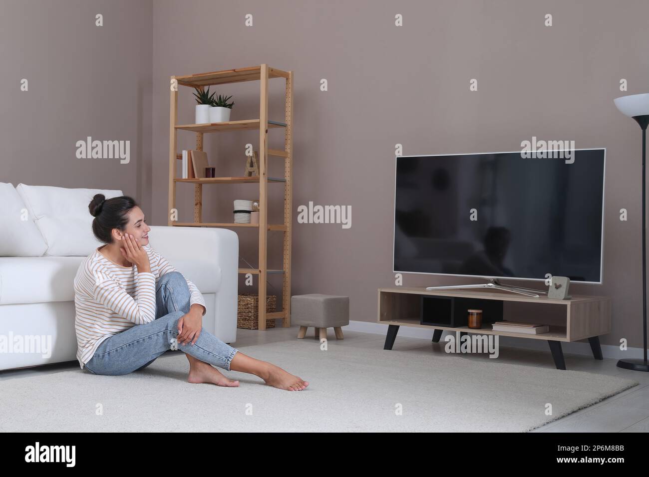 Woman watching television at home. Living room interior with TV on ...