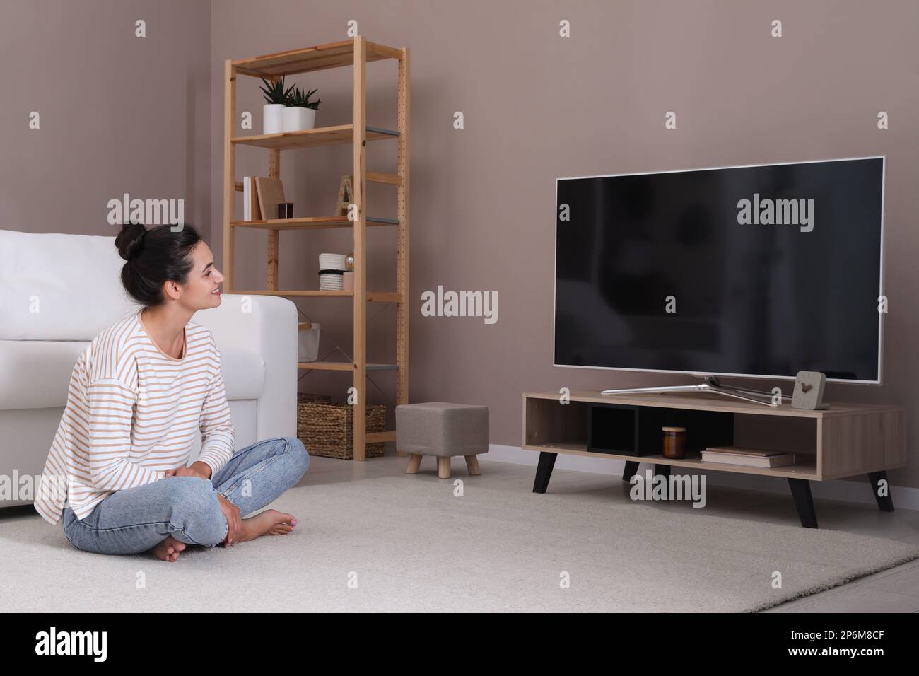 Woman watching television at home. Living room interior with TV on ...
