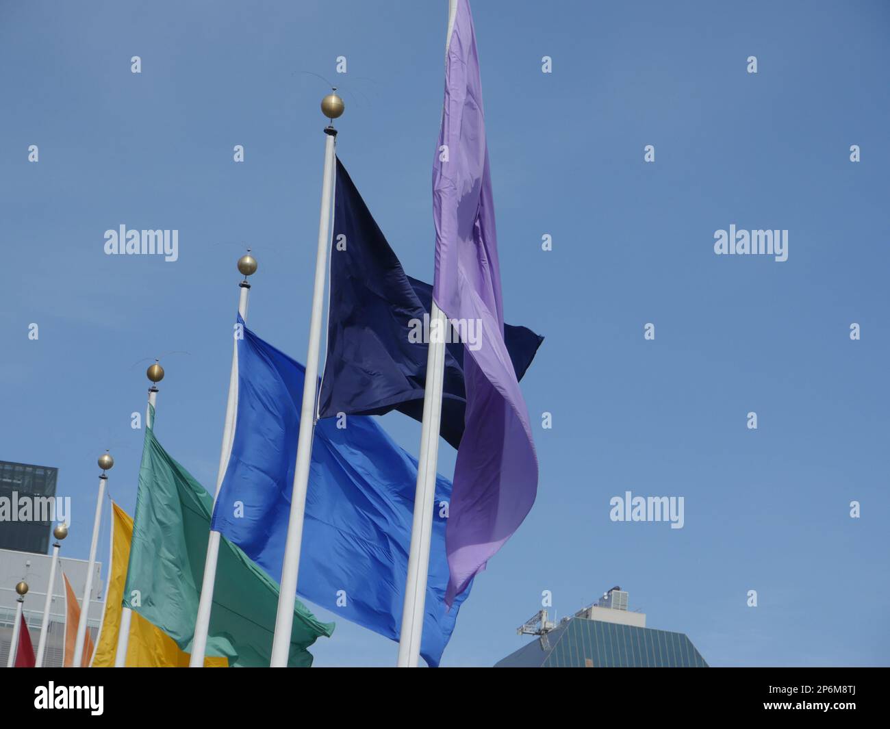 Flags of different colors on flagpoles Stock Photo - Alamy