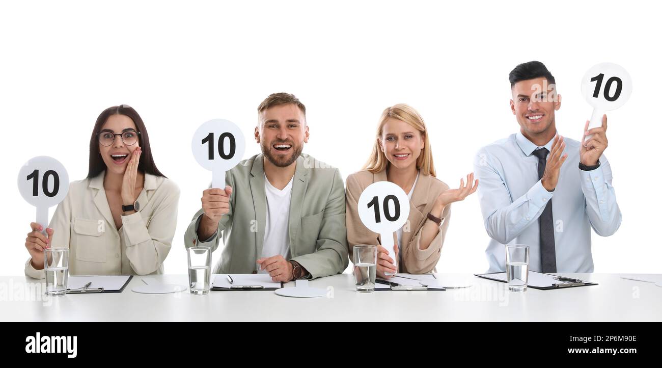 Panel of judges holding signs with highest score at table on white ...