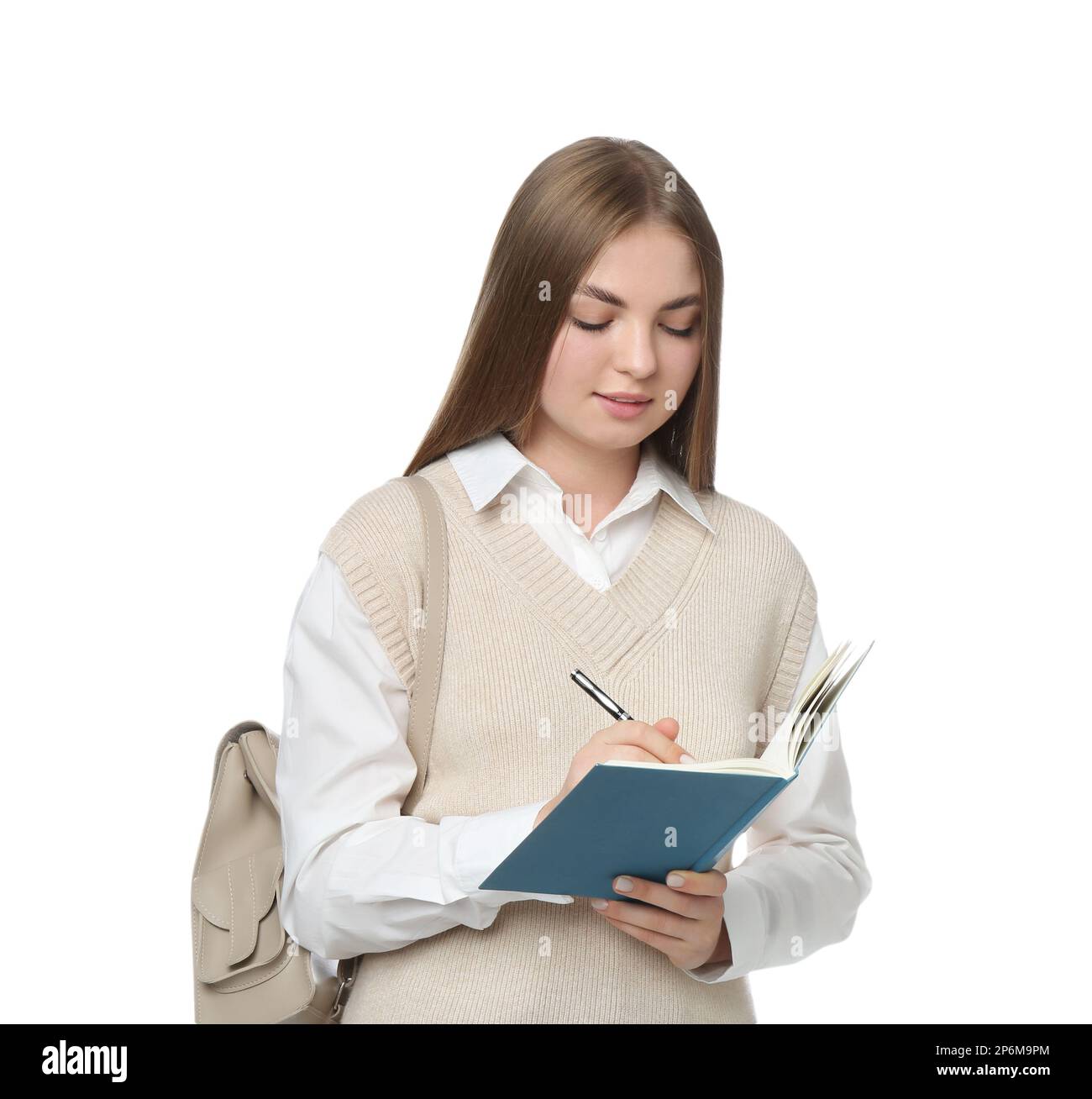 Teenage student with backpack writing in notebook on white background ...