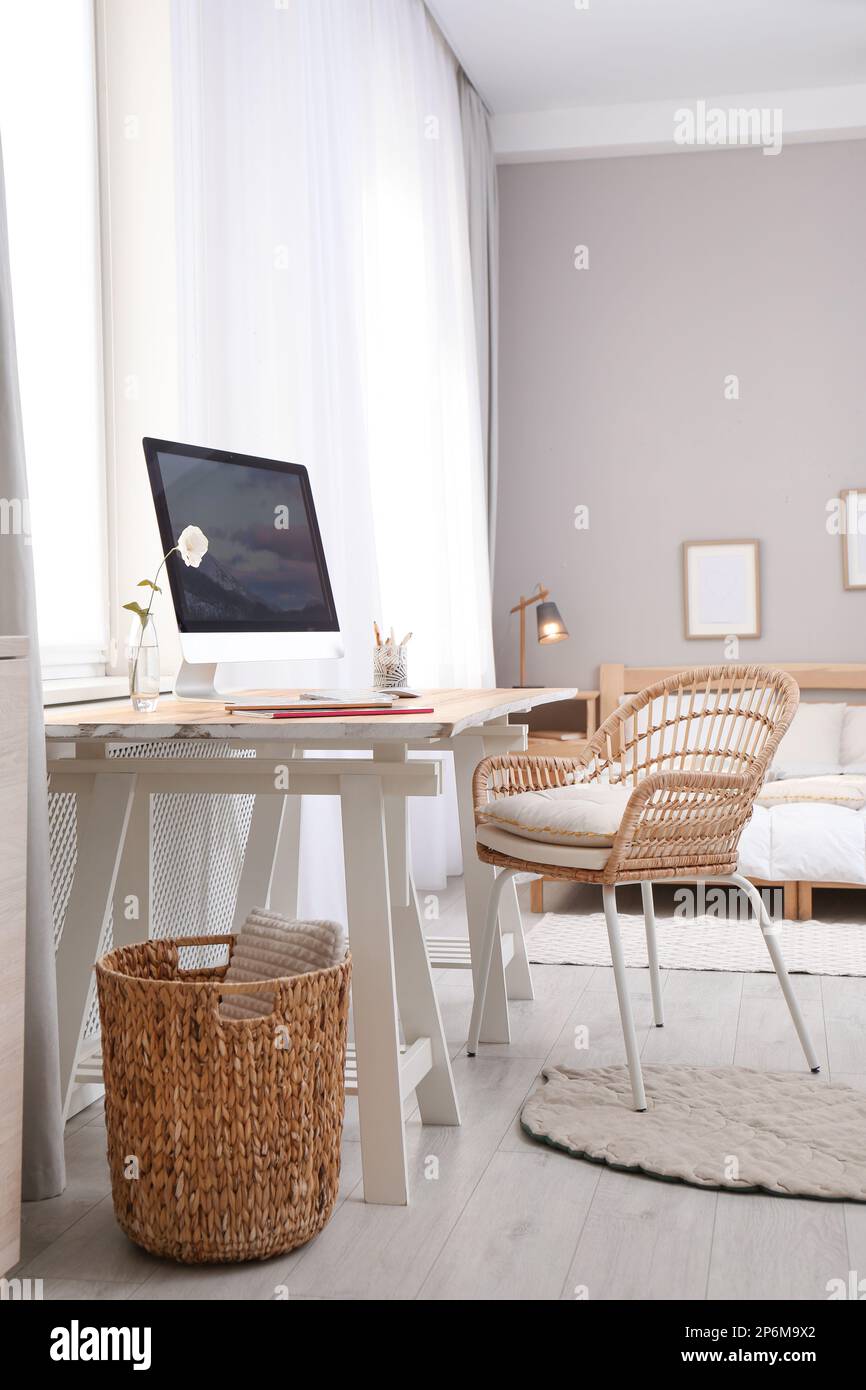 Comfortable workplace with modern computer near window in bedroom ...