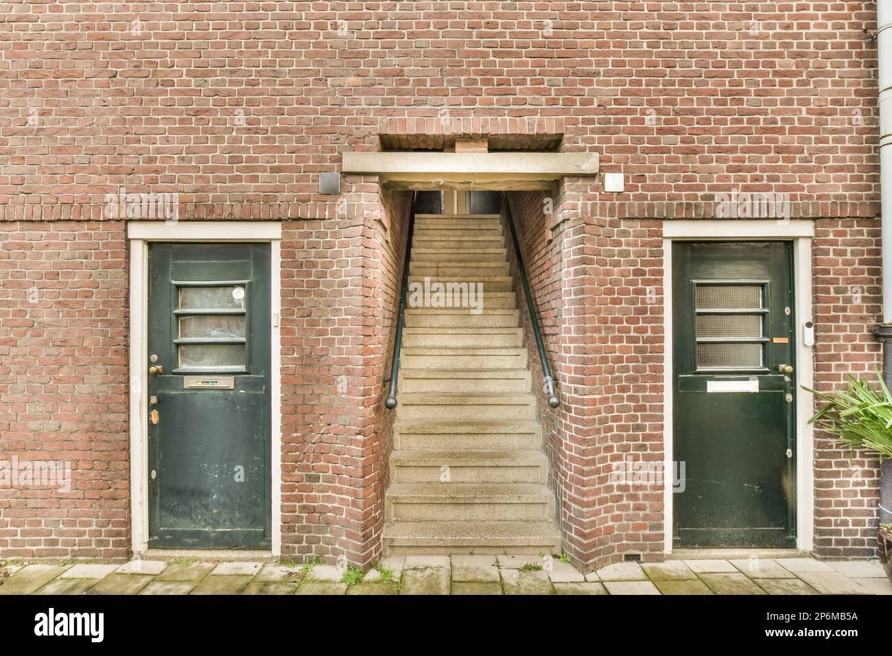 an old brick building with two doors and steps leading up to the front ...