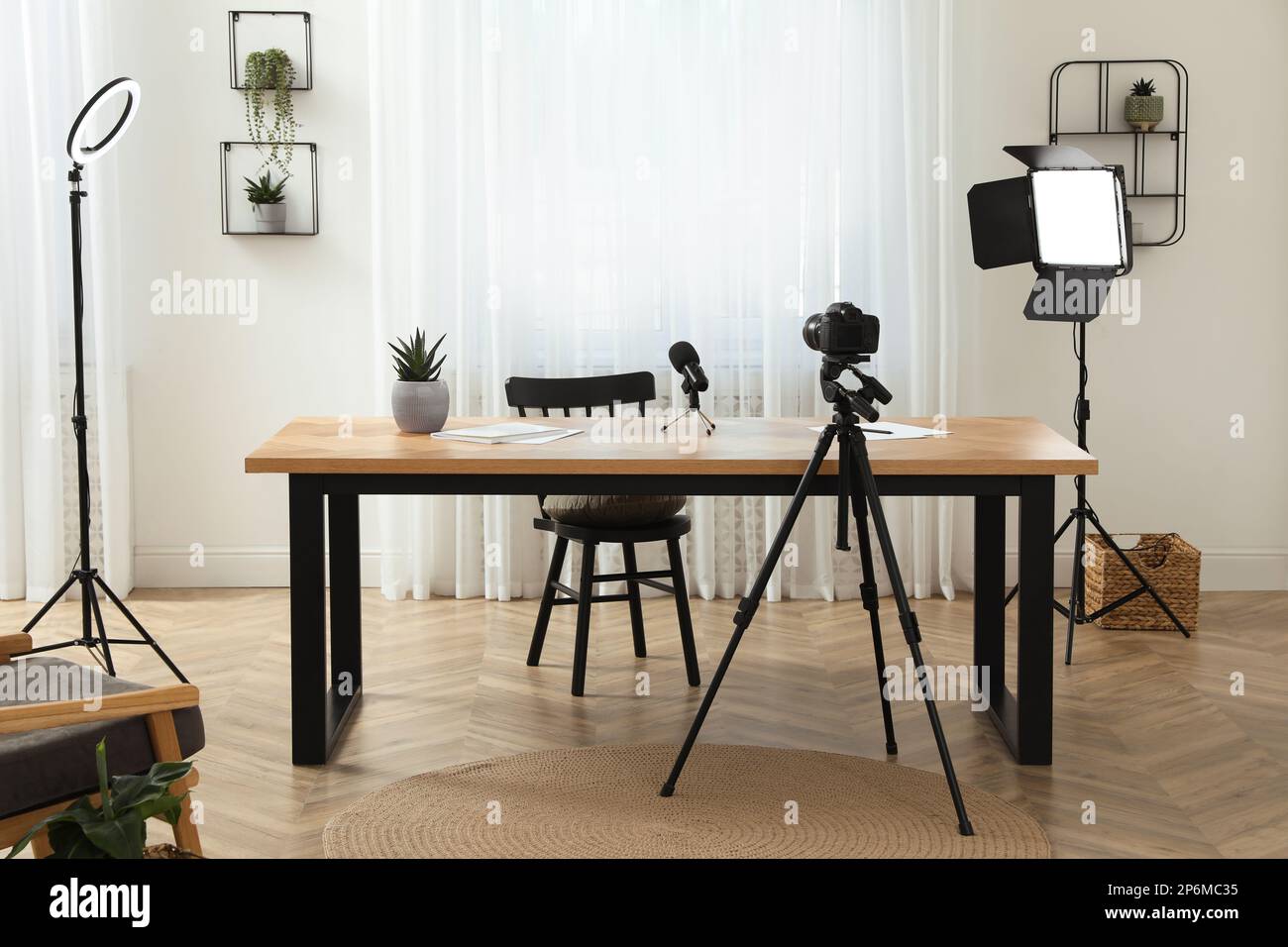 Camera and lighting equipment on tripods near table in room. Blogger ...
