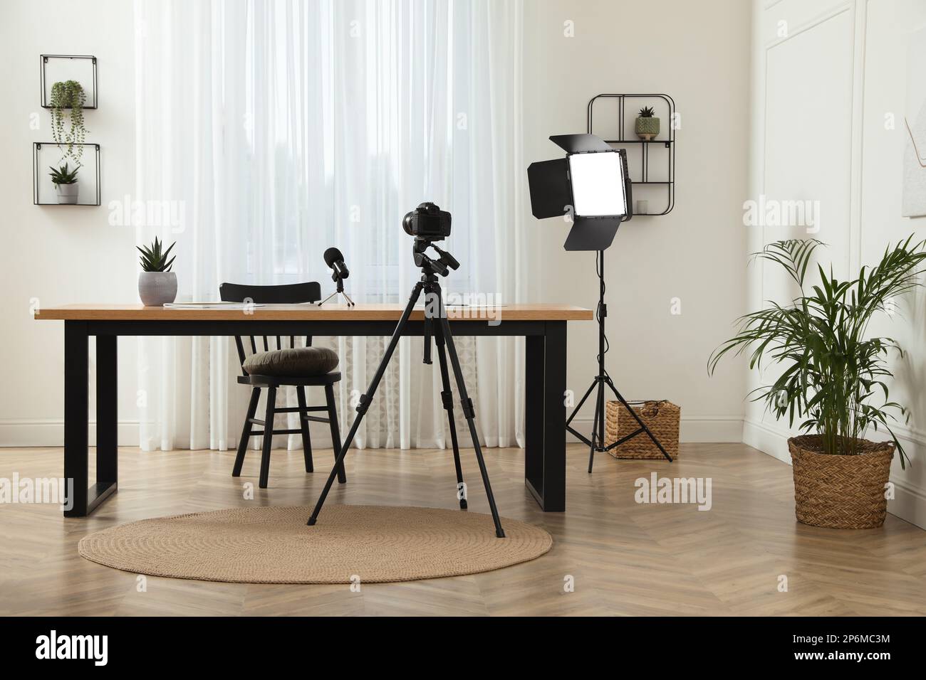 Camera and lighting equipment on tripods near table in room. Blogger ...