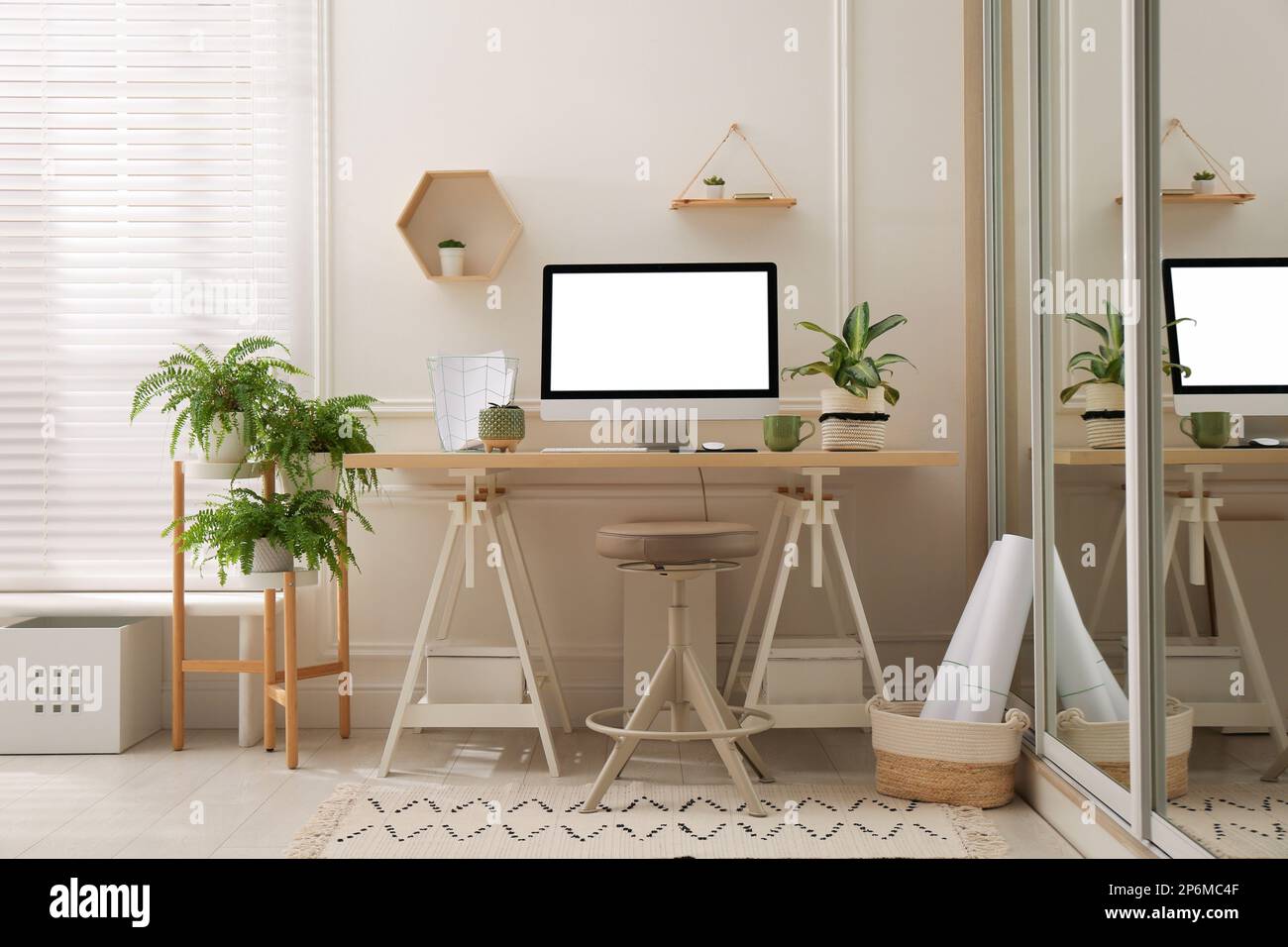 Comfortable workplace with modern computer and houseplants in room ...