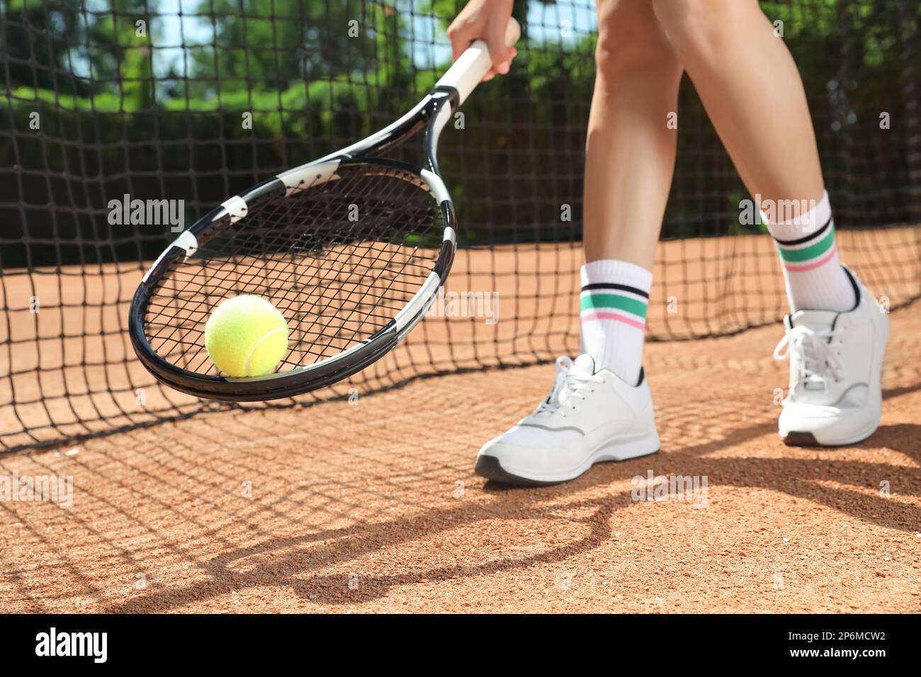 Woman with tennis racket and ball on court, closeup Stock Photo - Alamy