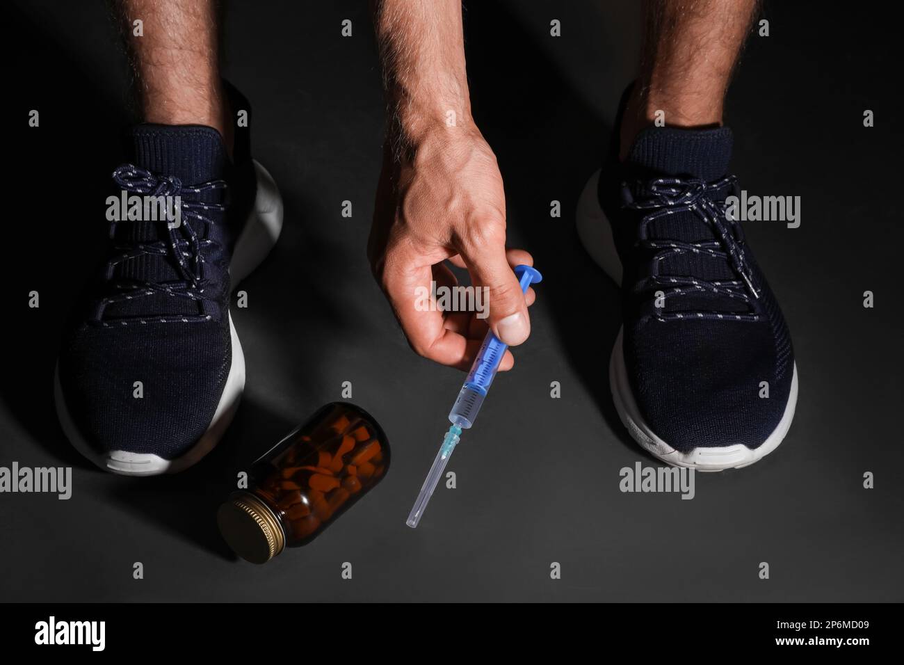 Man taking syringe from black floor, closeup. Doping concept Stock ...