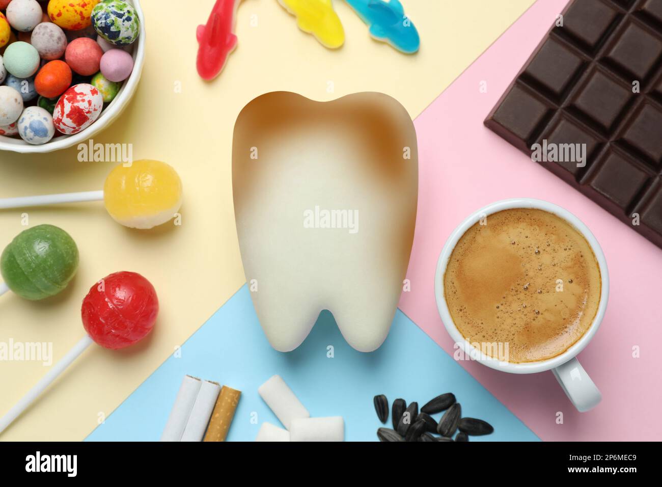 Decayed tooth model and harmful for enamel products on color background ...