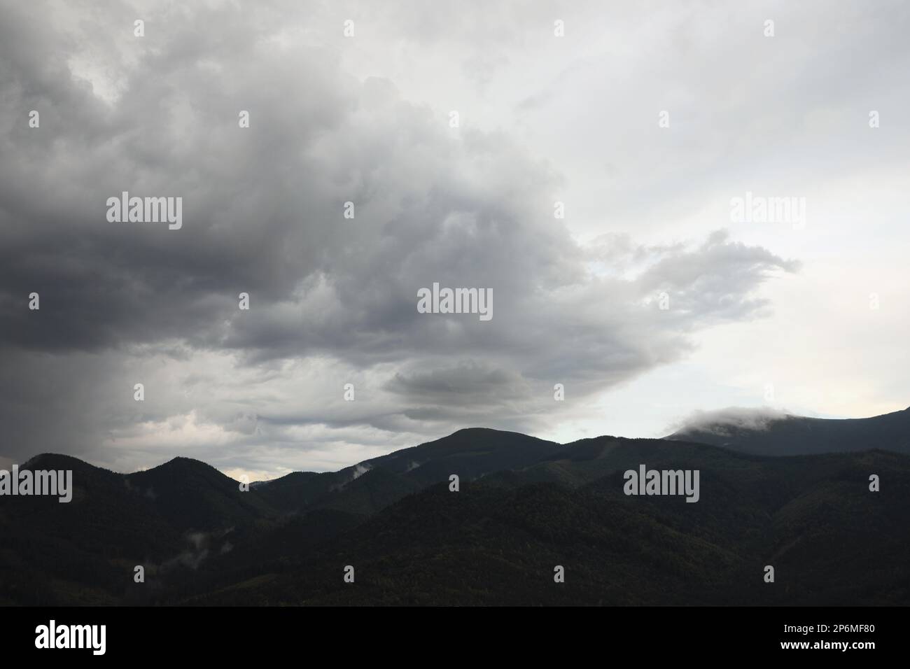 View of sky with grey thunder clouds over mountains Stock Photo - Alamy