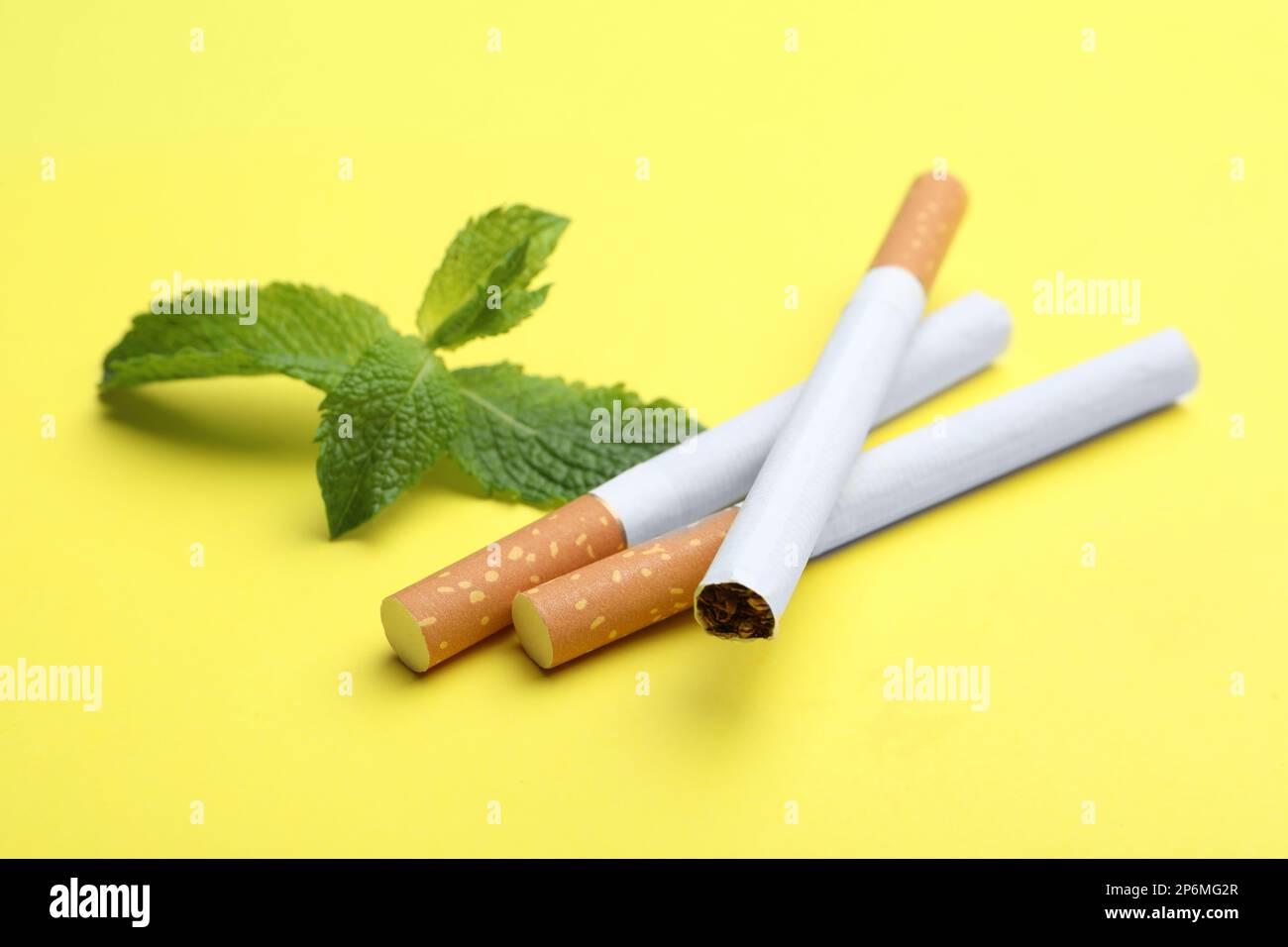Menthol cigarettes and mint on yellow background Stock Photo - Alamy