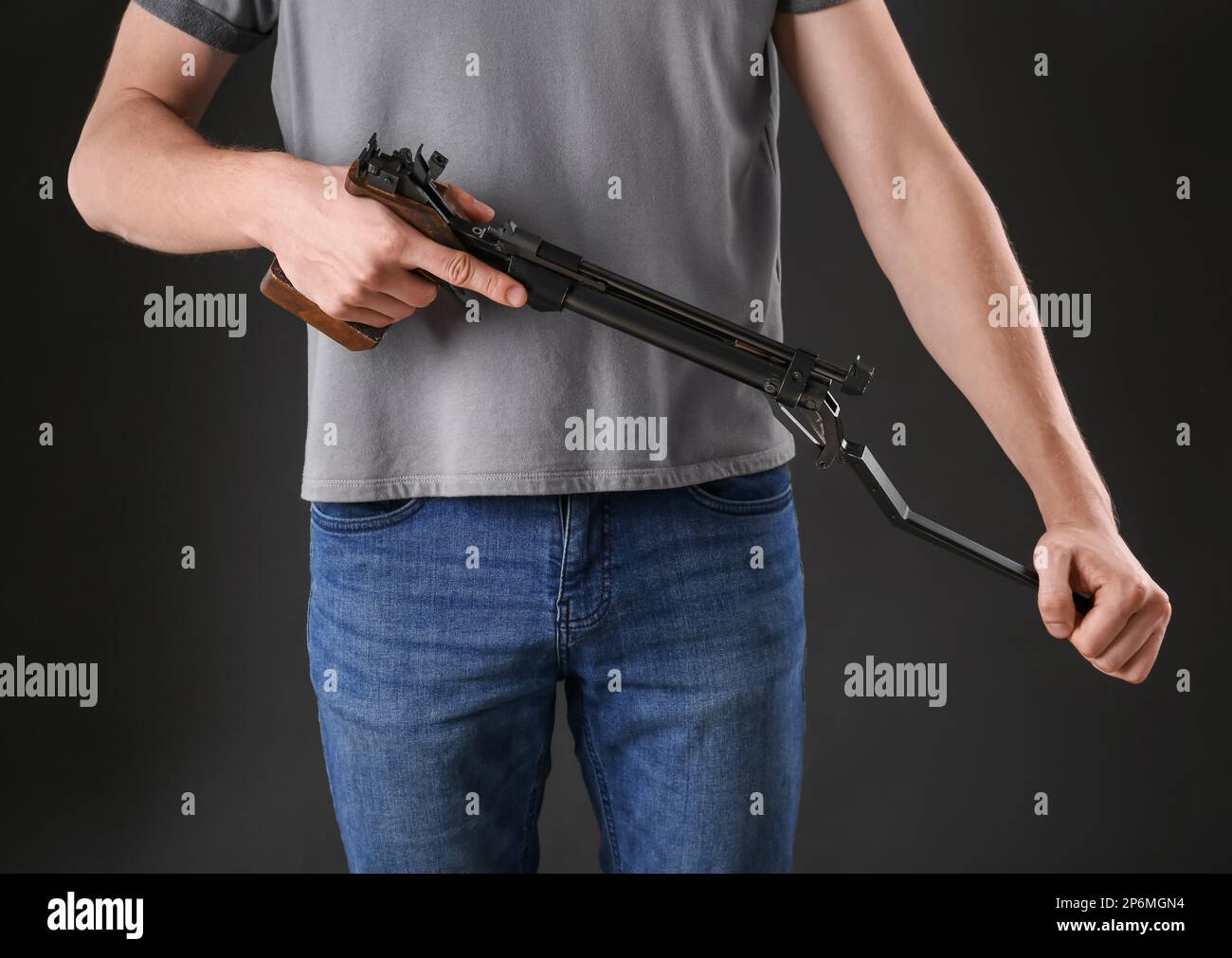 Gun shooting sport. Man holding standard pistol on dark background ...