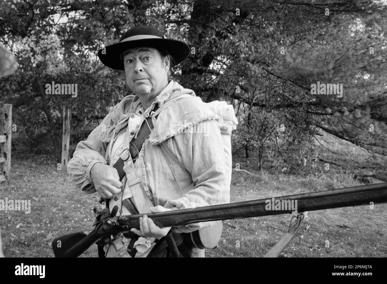 An actor in frontiersman costume preparing a musket for battle during a ...