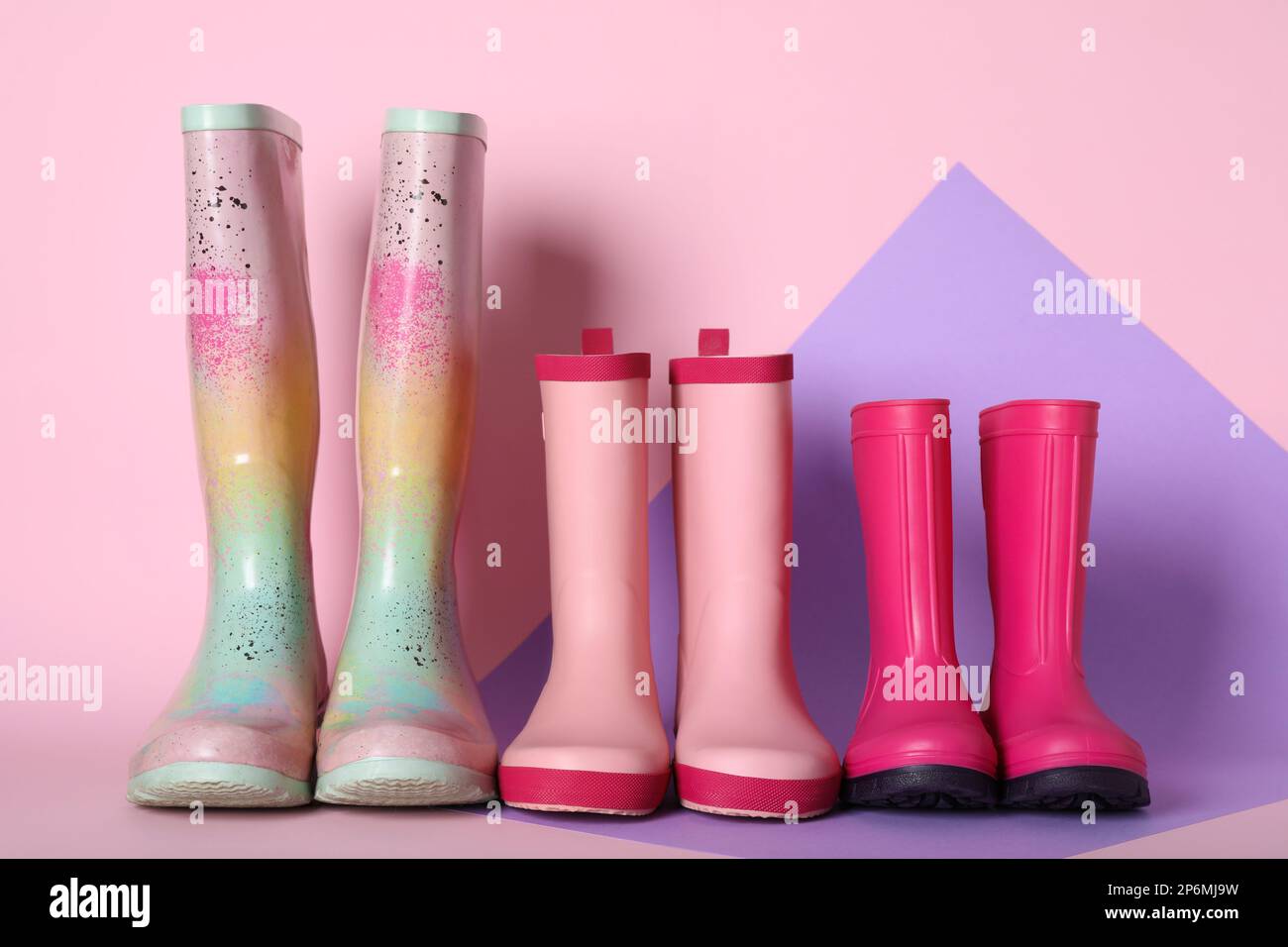 Three pairs of rubber boots on color background Stock Photo - Alamy