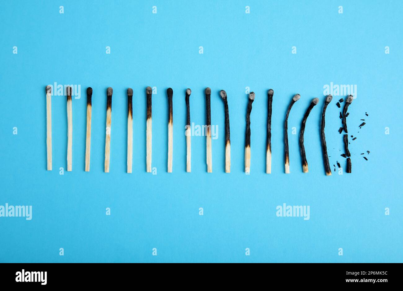 Different stages of burnt matches on light blue background, flat lay ...