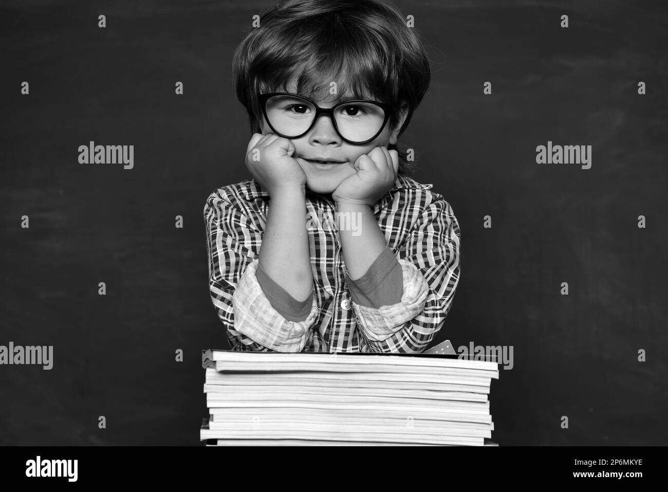 Cute boy with happy face expression near desk with school supplies ...