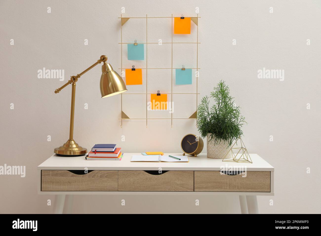 Memo board with colorful notes hanging on white wall over desk indoors ...