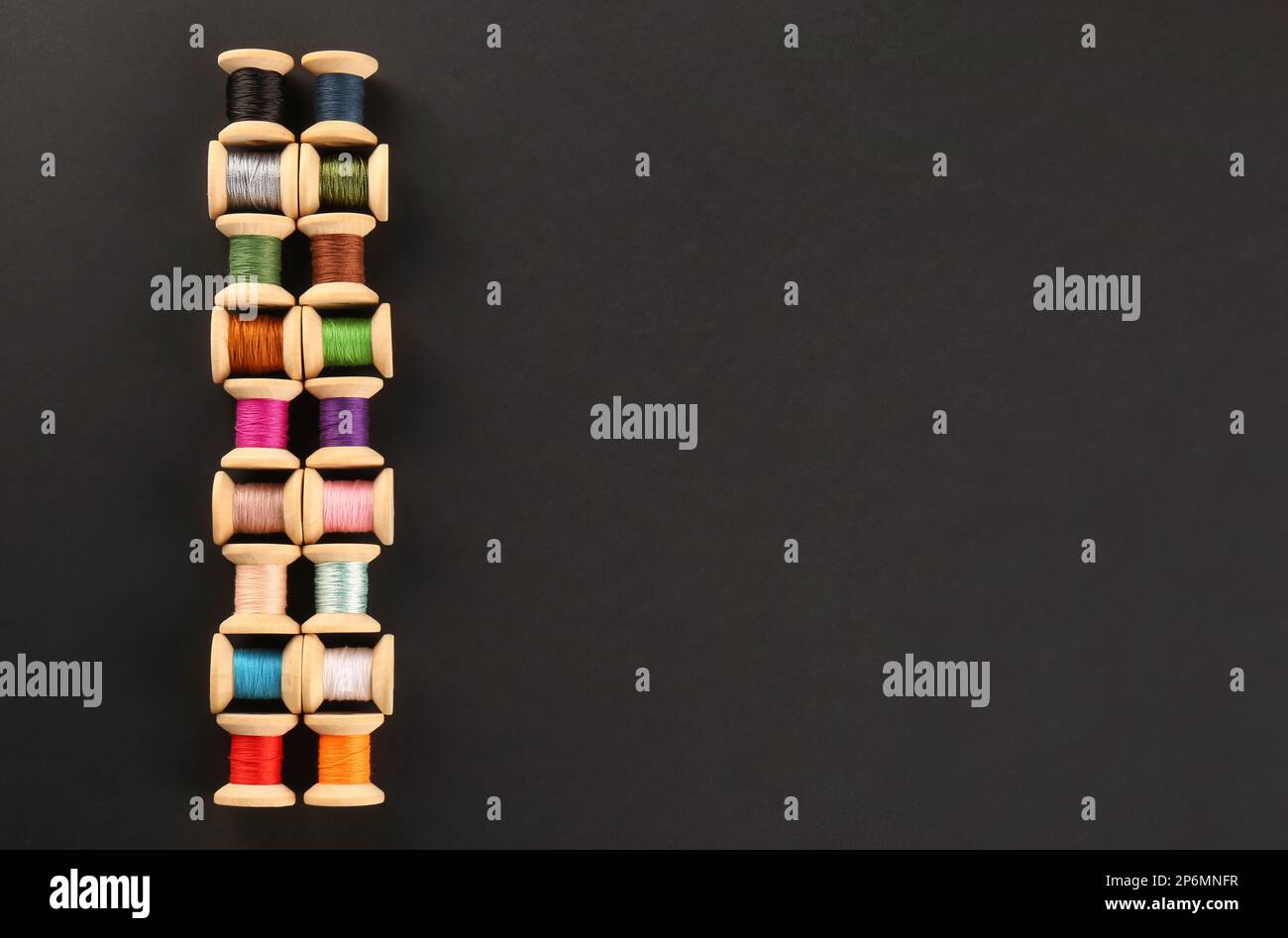 Different sewing threads on black background, flat lay. Space for text ...