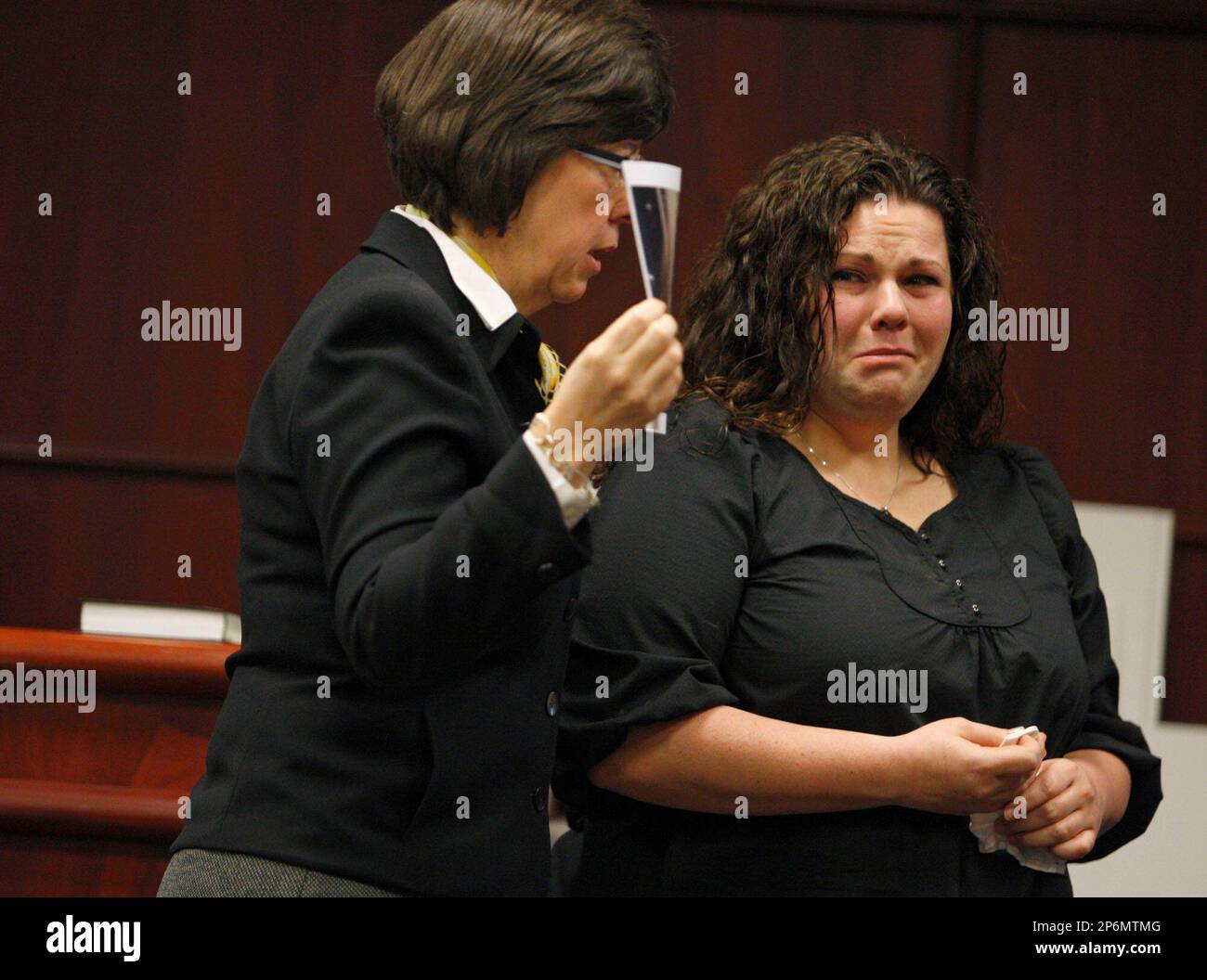 Meredith Fisher, sister of Michelle Young, right, tears up as she looks ...