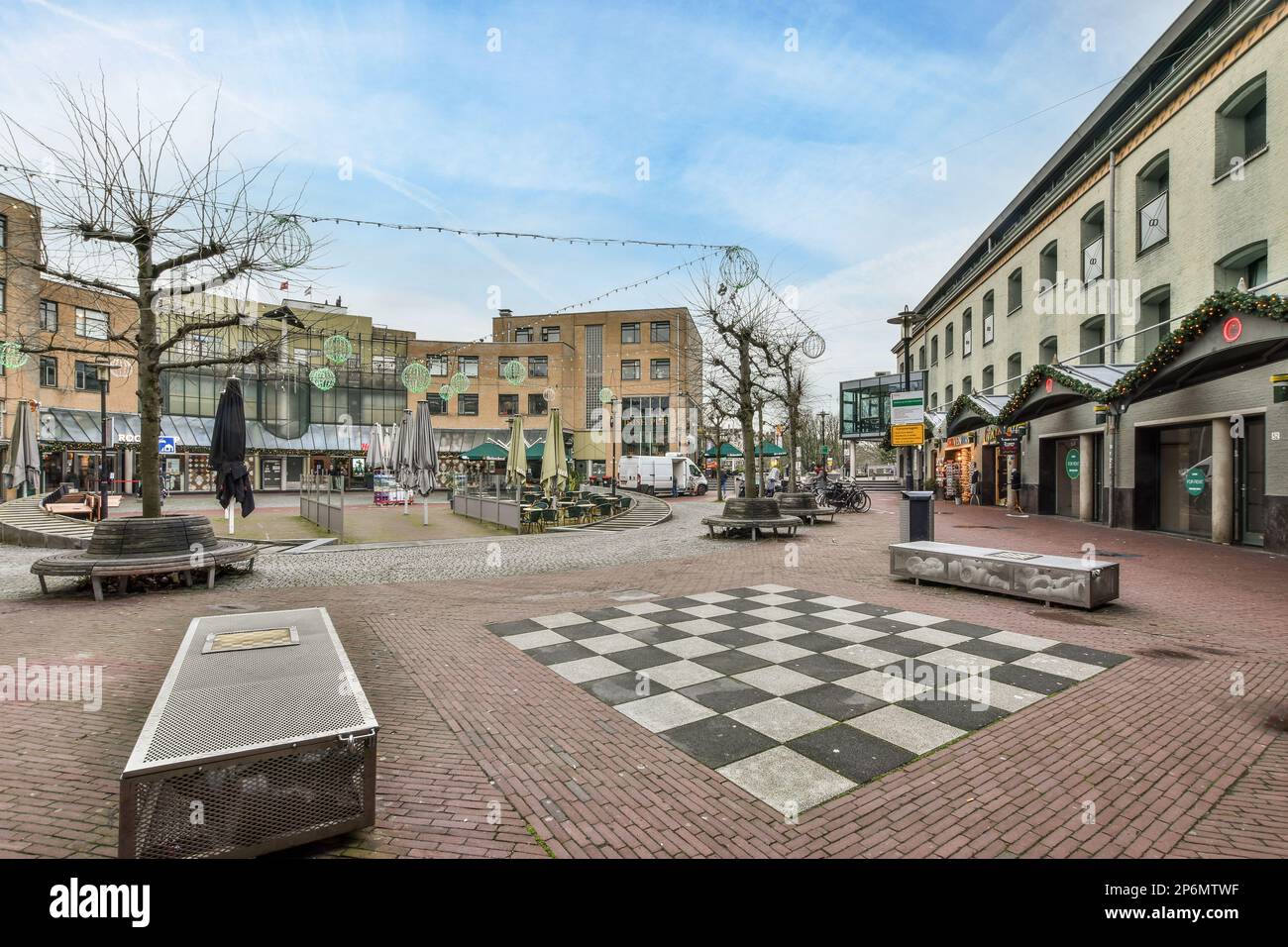 a city square with benches and tables in the middle of the street there ...