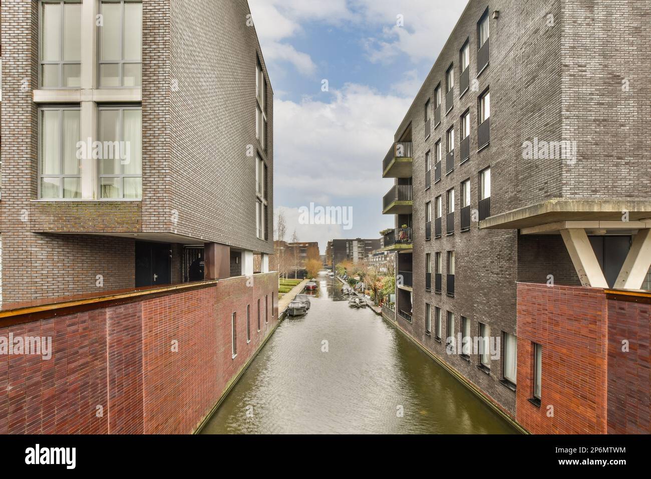 a canal in the middle of an urban area with brick buildings on both ...