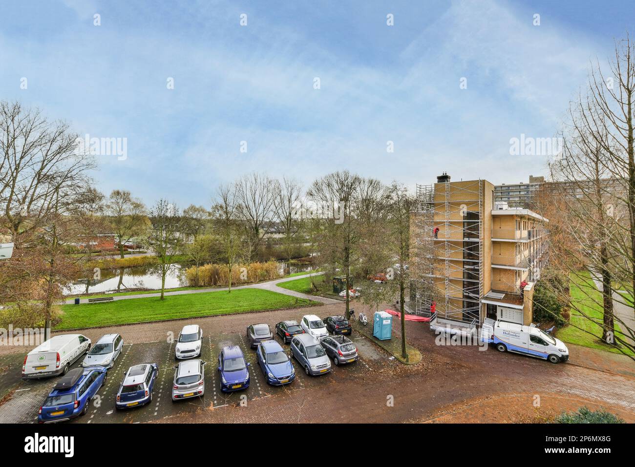 a parking lot with cars parked in it and some buildings on the other ...