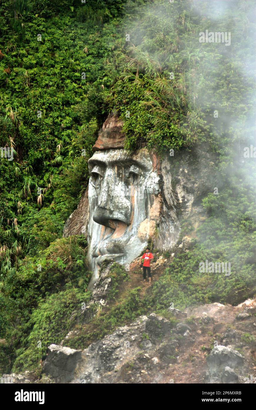 A visitor is spotted near a giant face formation illustrating the ...